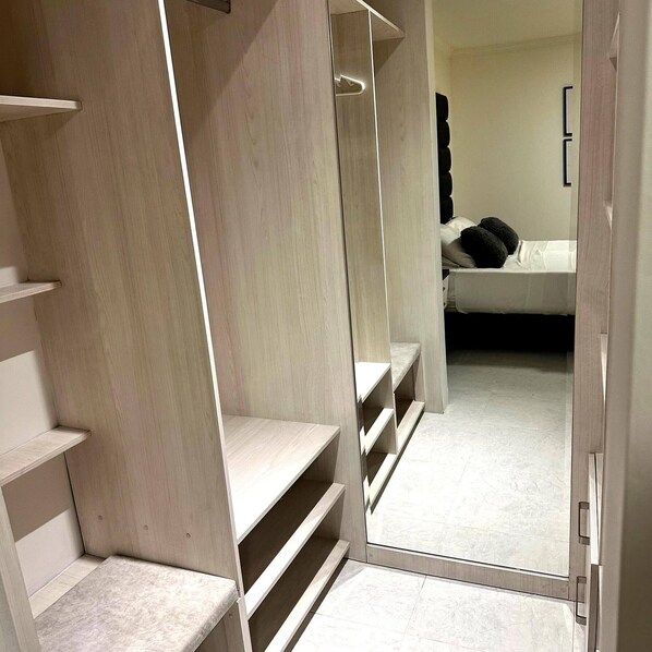 Quarto moderno com guarda-roupa embutido e porta de armário com espelho.