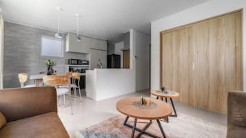 Um espaço de estar moderno com cozinha, sala de jantar e um guarda-roupa grande de madeira.