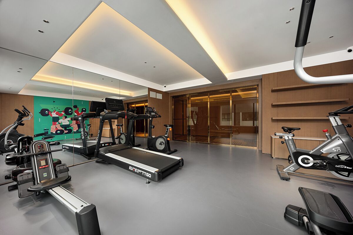 Uma academia moderna com diversos equipamentos de exercícios, incluindo esteiras, bicicletas ergométricas e aparelhos de musculação.