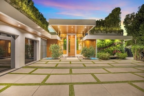 Uma casa moderna com um pátio amplo, um deck de madeira e um jardim bem cuidado.