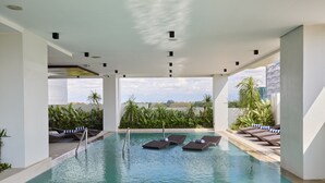 A rooftop pool with lounge chairs and a view of the cityscape.