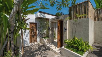 Uma villa moderna com porta de madeira, parede branca com janela e uma placa com o nome 'VILLA JUNE'.