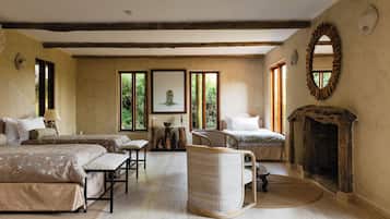 Quarto com duas camas, lareira e um espelho grande.