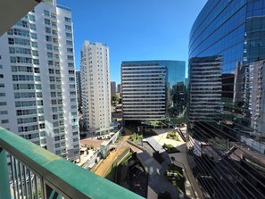 Um edifício alto com fachada de vidro moderna, cercado por outros edifícios altos.