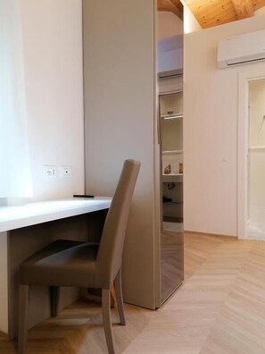 Um quarto com escrivaninha, cadeira e estante.