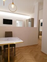 Um interior moderno com uma mesa de jantar, cadeiras, uma televisão e um espelho.
