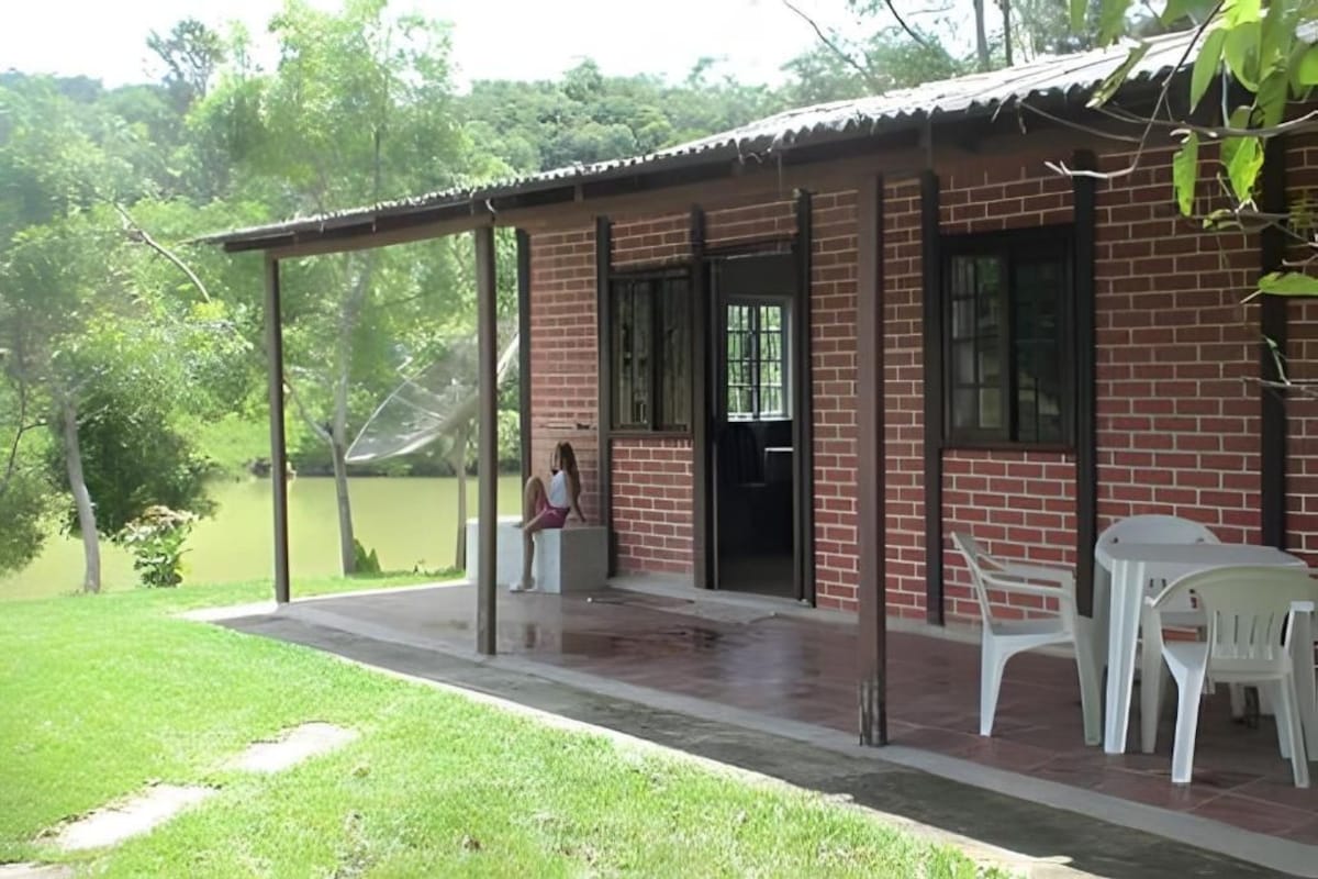 Um edifício de tijolos com varanda coberta, uma janela e uma porta.