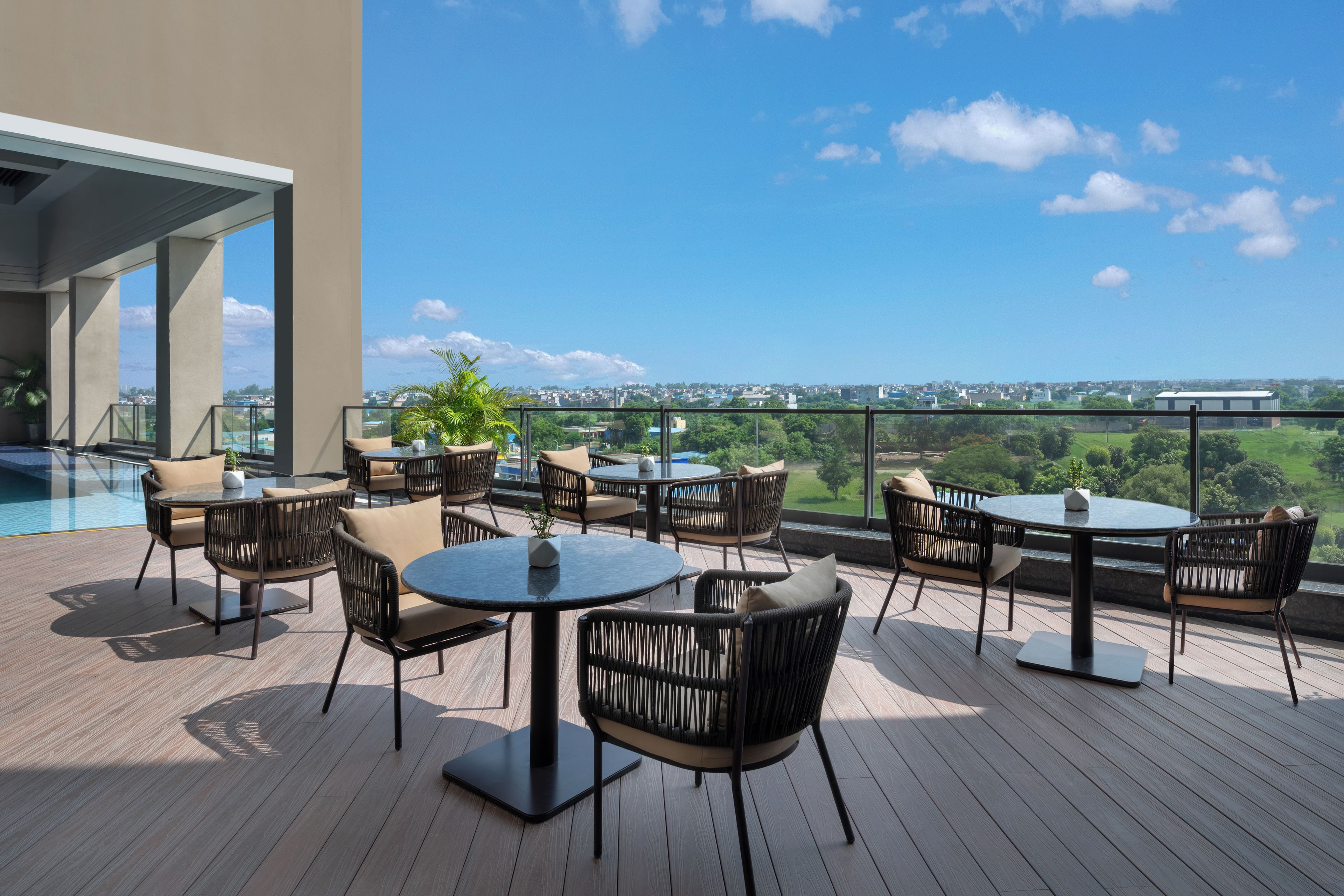 Terraço no telhado com área de estar externa e vista para a paisagem urbana.