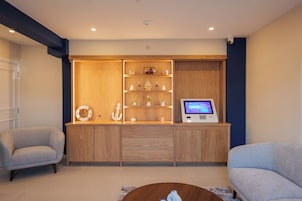 Uma sala de estar moderna com um móvel de entretenimento de madeira, uma televisão e dois sofás.