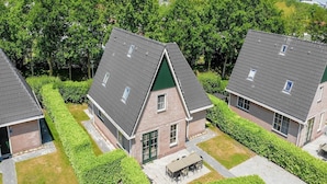 A residential area with houses featuring sloped roofs and brick exteriors.