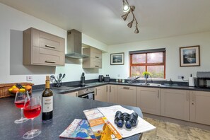 Uma cozinha moderna com uma garrafa de vinho, copos e um mapa sobre o balcão.