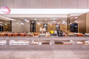 Um buffet de café da manhã moderno em um hotel, com diversas opções de comida e design contemporâneo.