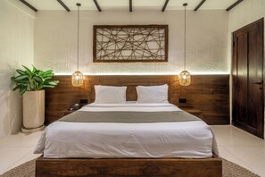 Quarto moderno com uma cama grande, duas luminárias de cabeceira, um vaso de planta e um objeto decorativo na parede.