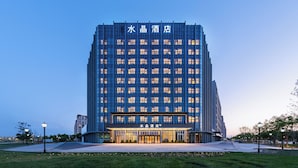 A modern hotel building with a large number of windows and a prominent entrance.
