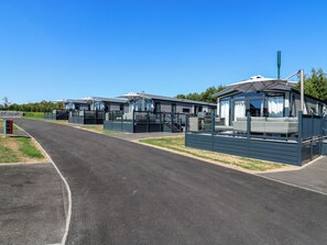 Fileira de casas móveis modernas, térreo, com grandes janelas e área de estar coberta.