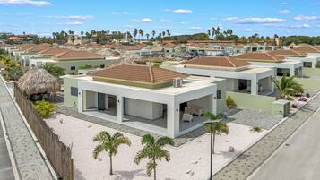 Um resort com villas modernas, cada uma com telhado de azulejos e área externa coberta.
