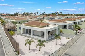 Um resort com villas modernas, cada uma com telhado de azulejos e área externa coberta.