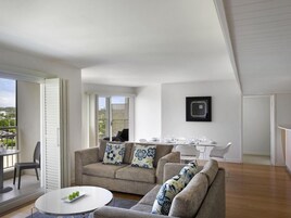Uma sala de estar moderna com sofá, mesa de jantar e varanda com área de estar externa.
