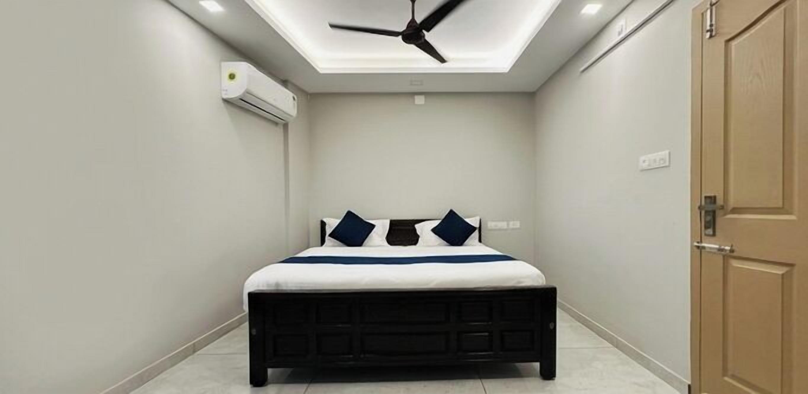 Quarto com cama, ventilador de teto e ar condicionado.