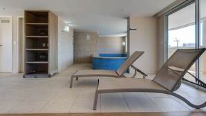 Uma casa de banho moderna com banheira, chuveiro e uma unidade de prateleiras embutida.