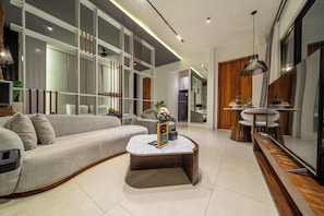 Uma sala de estar moderna com sofá, mesa de centro e área de jantar com mesa e cadeiras.