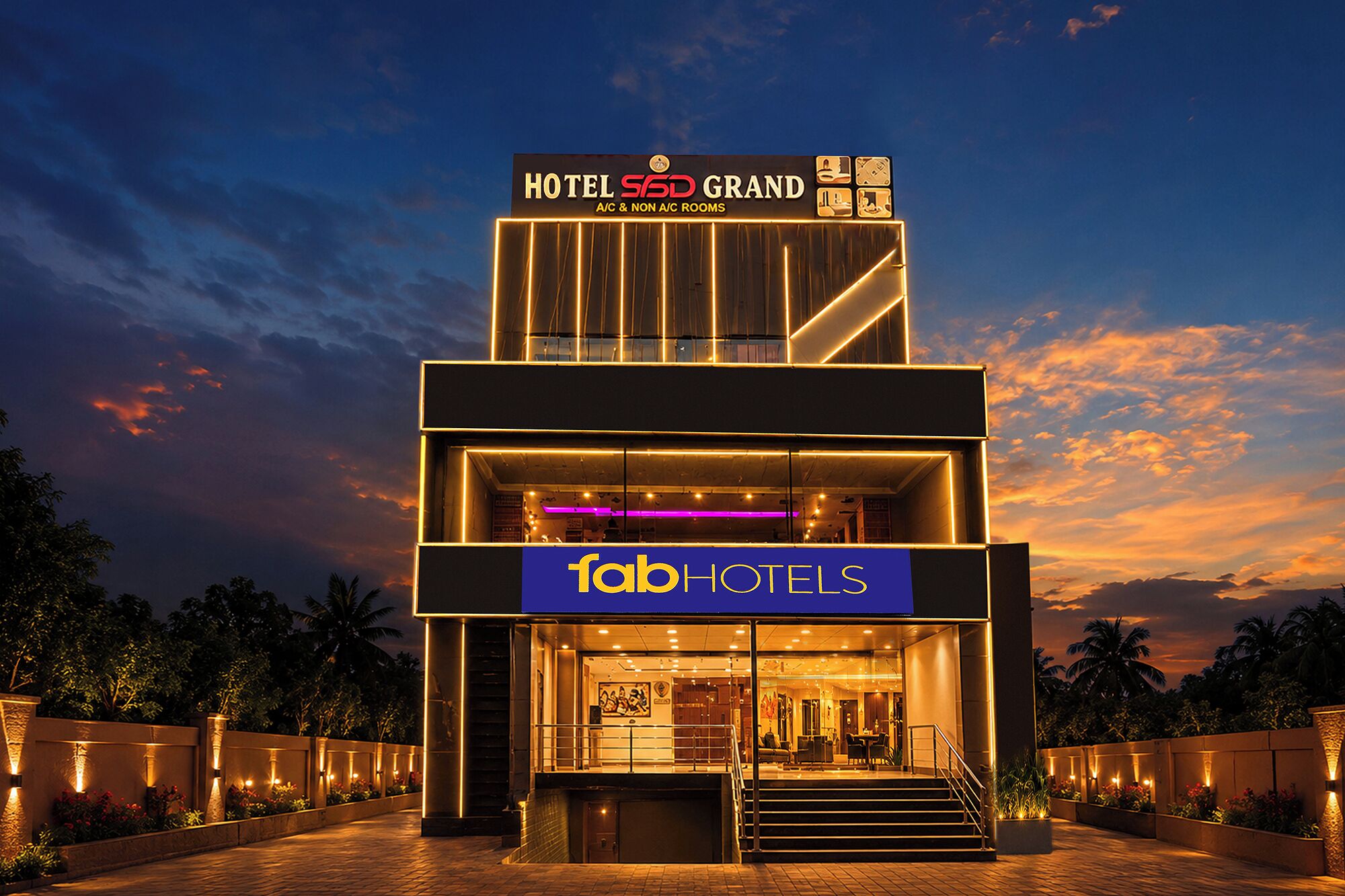 Hotel com design moderno, exibindo uma placa grande com a inscrição 'Hotel SBD Grand' e a marca 'FabHotels'.