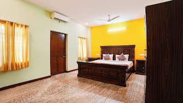 Quarto com cama, ventilador de teto e armário de madeira.