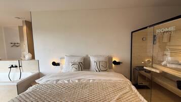 Um quarto moderno com uma cama grande, uma mesa de cabeceira, um espelho e um separador de vidro com interior em madeira.