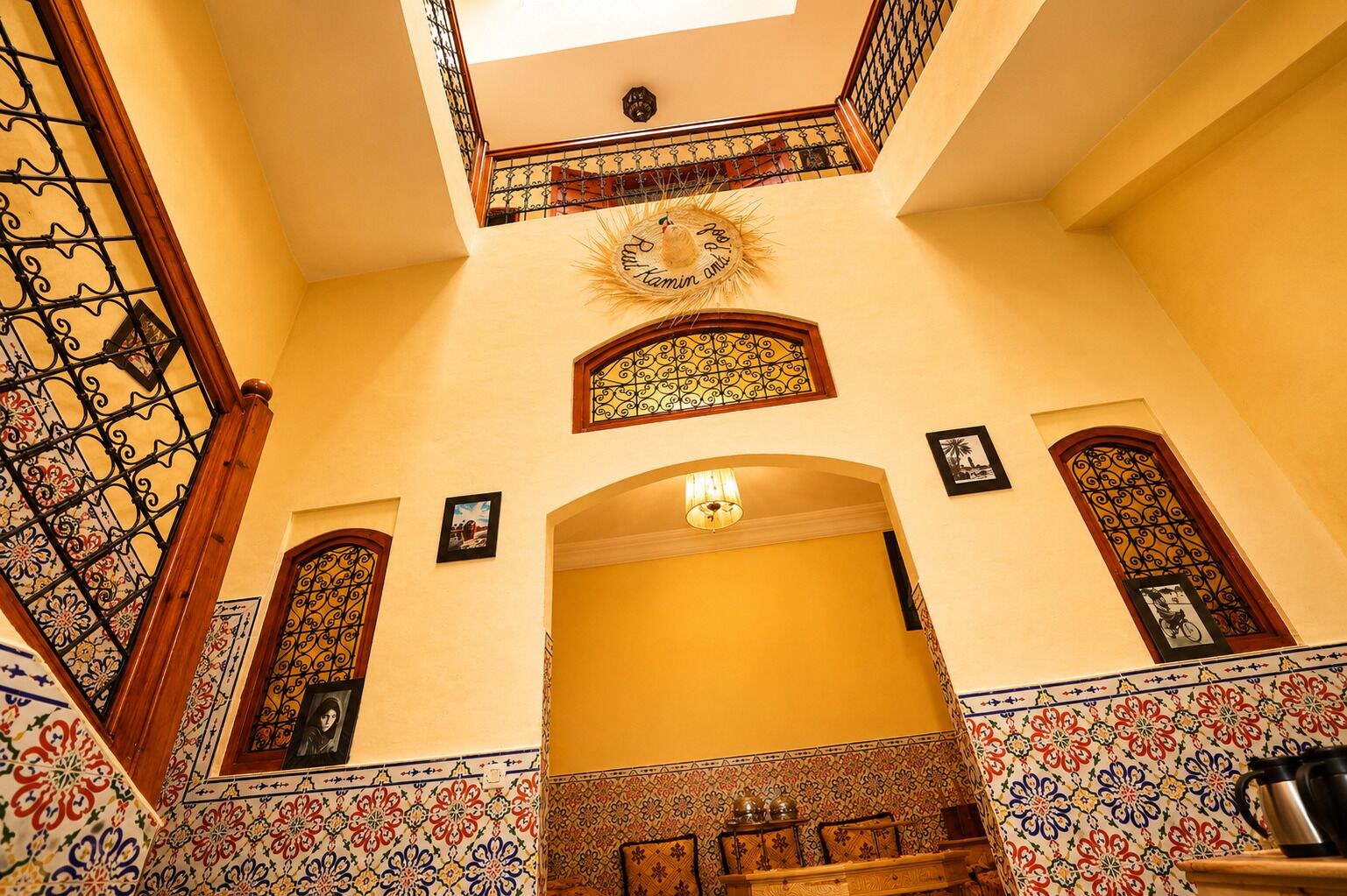 Uma escadaria com grades de metal elaboradas e paredes revestidas com azulejos estampados.