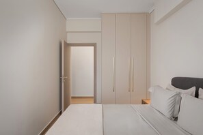 Um quarto com uma cama, um guarda-roupa e uma mesa de cabeceira.