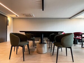 Uma área de refeições moderna com uma mesa comprida e várias cadeiras.