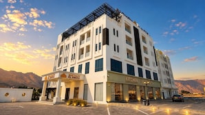 Um hotel com vários andares e design arquitetônico moderno, com um restaurante de destaque chamado 'Kitchen' no andar térreo.