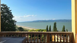 Uma varanda com vista para um lago e montanhas ao longe.