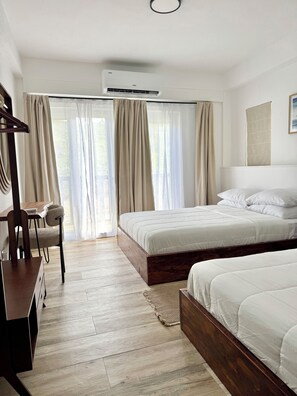 Quarto com duas camas, uma escrivaninha e uma cadeira.