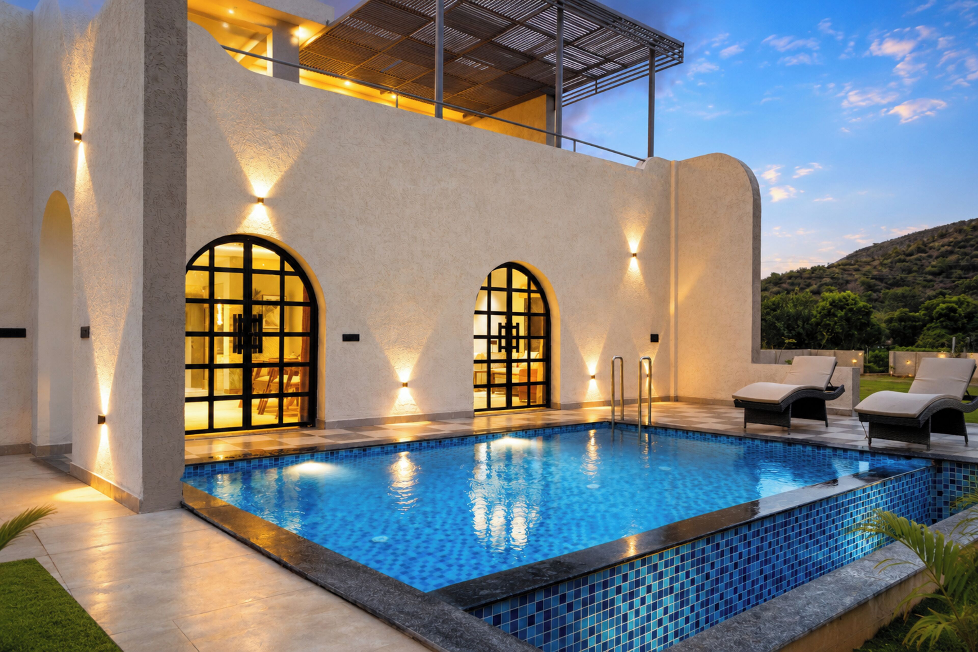 Um edifício moderno com piscina, área de estar ao ar livre e vista para a paisagem circundante.