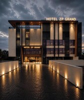 Um edifício moderno de hotel com entrada destacada e sinalização iluminada.
