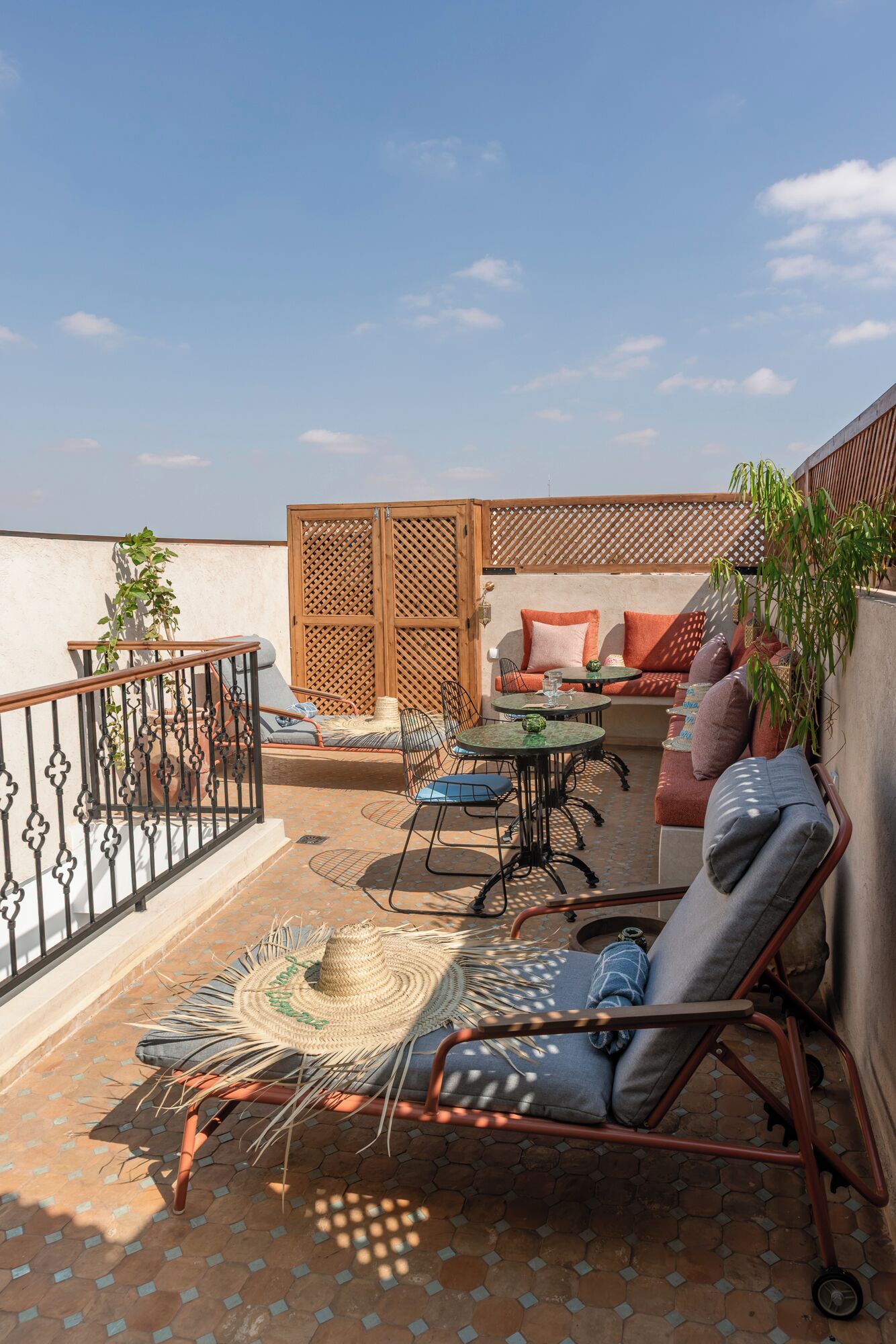 Terraço no telhado com área de estar, mesa e espreguiçadeira.