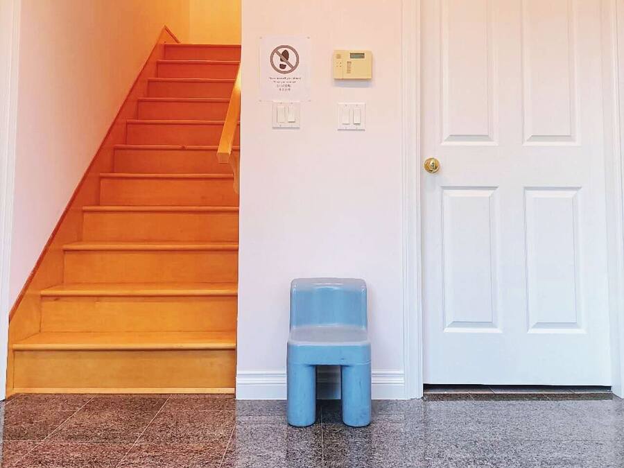 Escadas que levam a uma porta com uma placa indicando lavanderia.