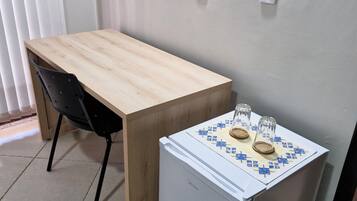 Uma pequena cozinha compacta com uma mesa de madeira e uma geladeira.