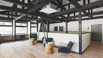 Um espaço interior com vigas aparentes, balcão de recepção e áreas de estar.