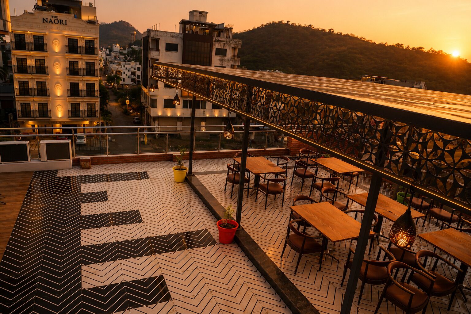 A rooftop terrace with outdoor seating and a view of the cityscape at sunset.