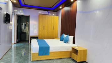 Quarto moderno com cama de madeira, mesa de cabeceira, guarda-roupa e banheiro visível através de uma porta aberta.