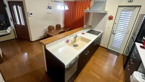 Uma cozinha compacta com uma ilha central, forno embutido e pia.