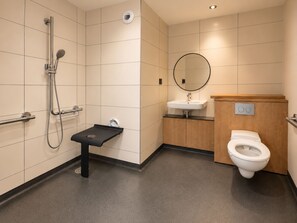 Uma casa de banho moderna com chuveiro, sanita e lavatório.
