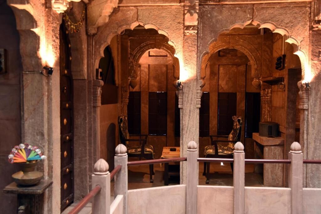 A room with a traditional archway entrance, a wooden table, and a chair.