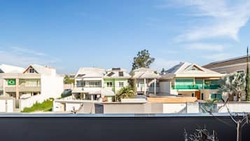 Um bairro residencial com várias casas, algumas equipadas com painéis solares, sob um céu azul e claro.