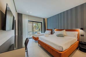 Quarto de hotel moderno com uma cama grande, uma escrivaninha e uma varanda com vista.