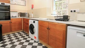 Uma cozinha equipada com máquina de lavar, forno e lava-louças.