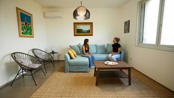 Villa Deluxe, vista para a baía | Sala de estar | Televisor de ecrã plano de 40 polegadas com canais digitais, livros