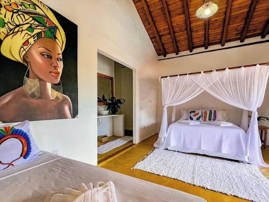 Um quarto com cama de dossel, um quadro na parede e teto de madeira.